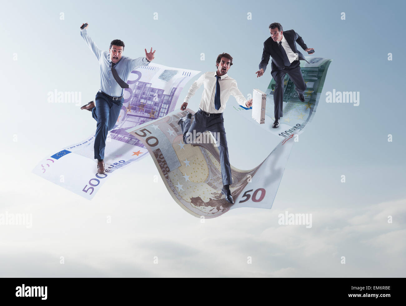 Businessmen running frantically on euros while floating in the sky ...
