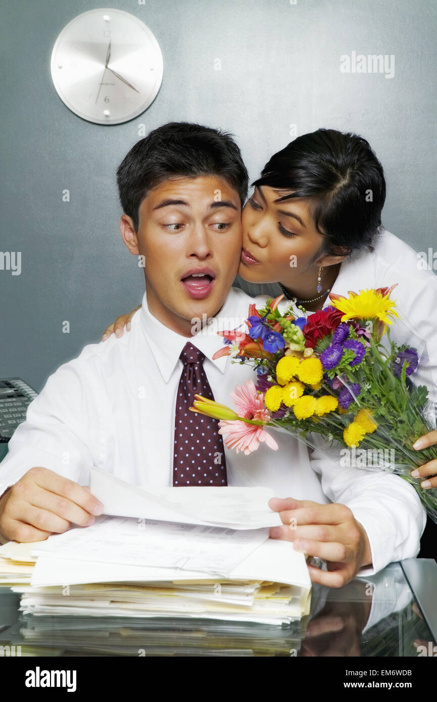 Businessman At Desk Covered In Paperwork, Attractive Woman Bringing Him ...