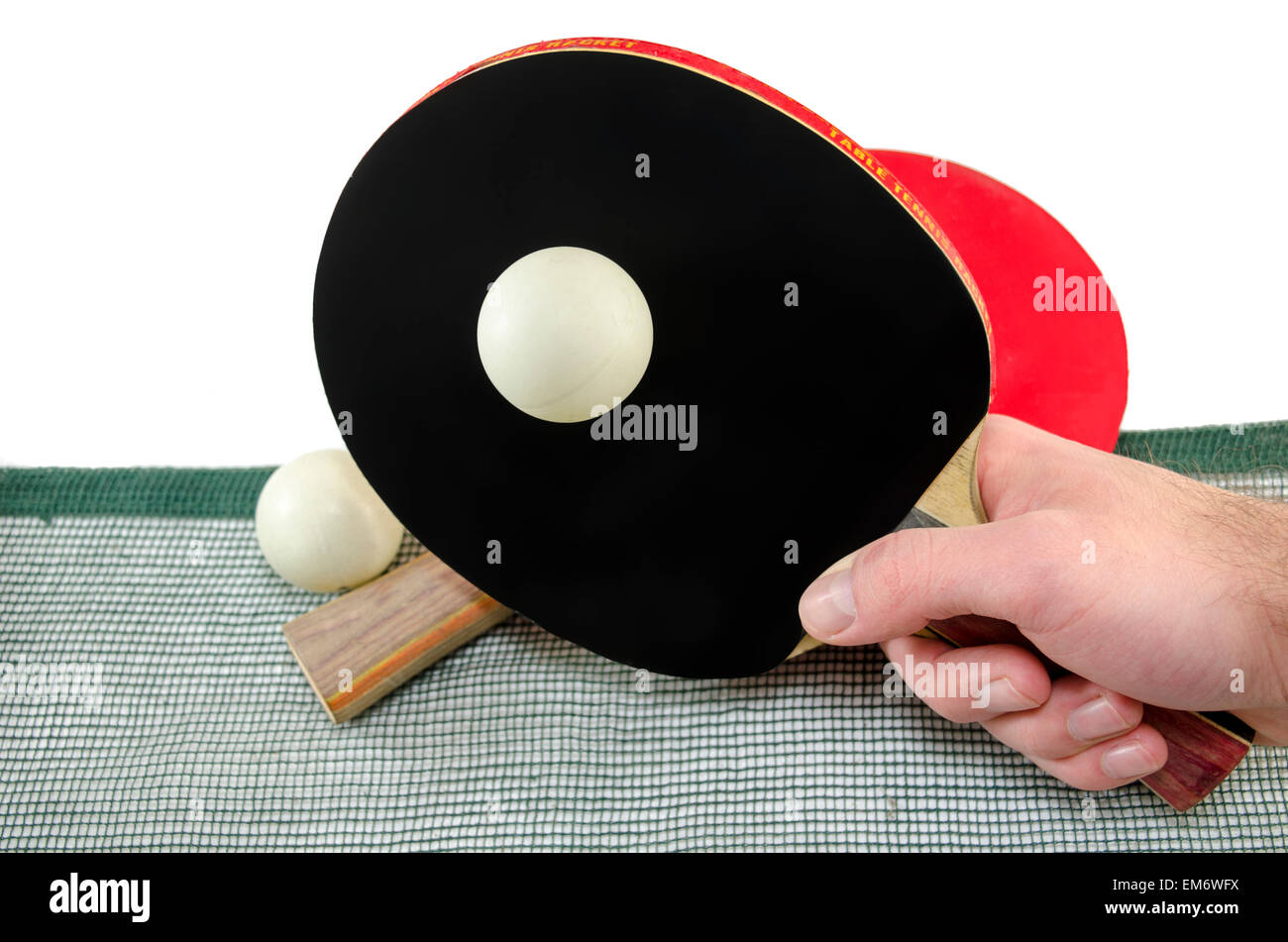 Male hand holding a ping pong racket and a table tennis ball above a ...
