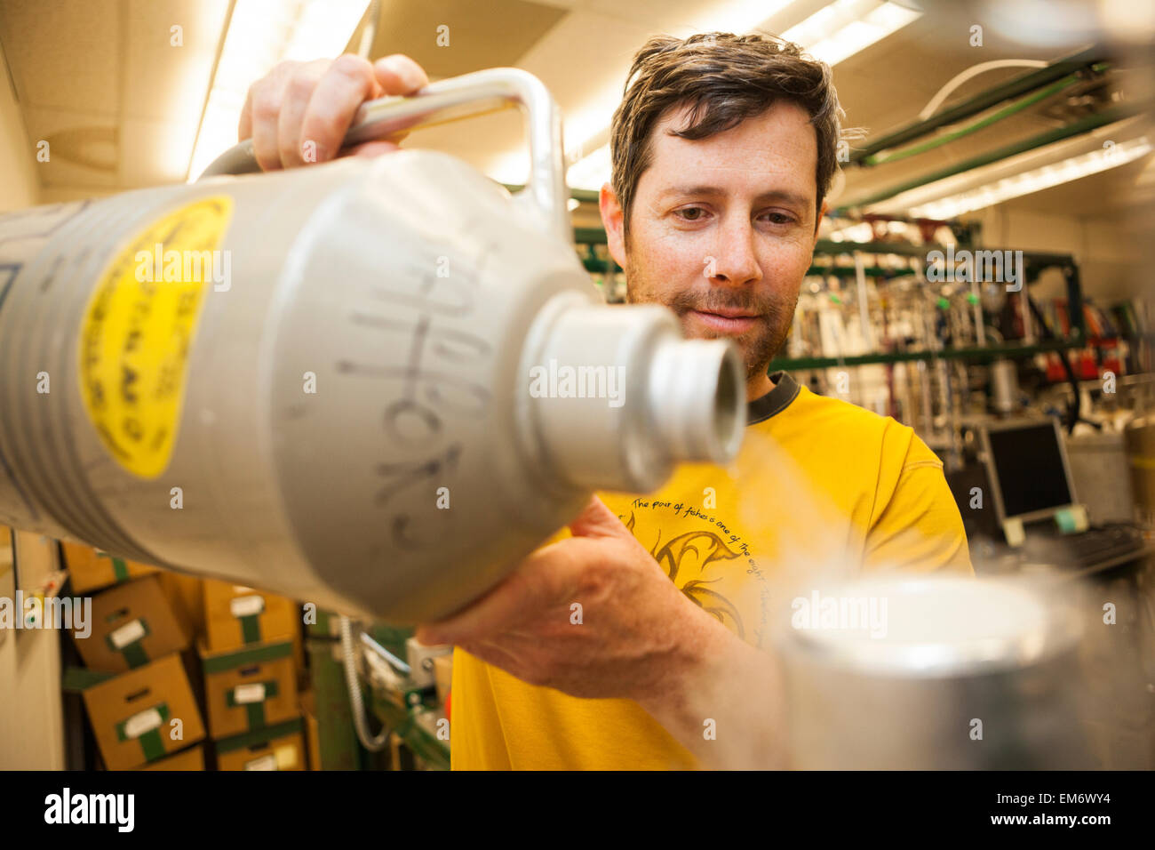 A man pours liquid nitrogen into a beaker at a radiocarbon laboratory ...