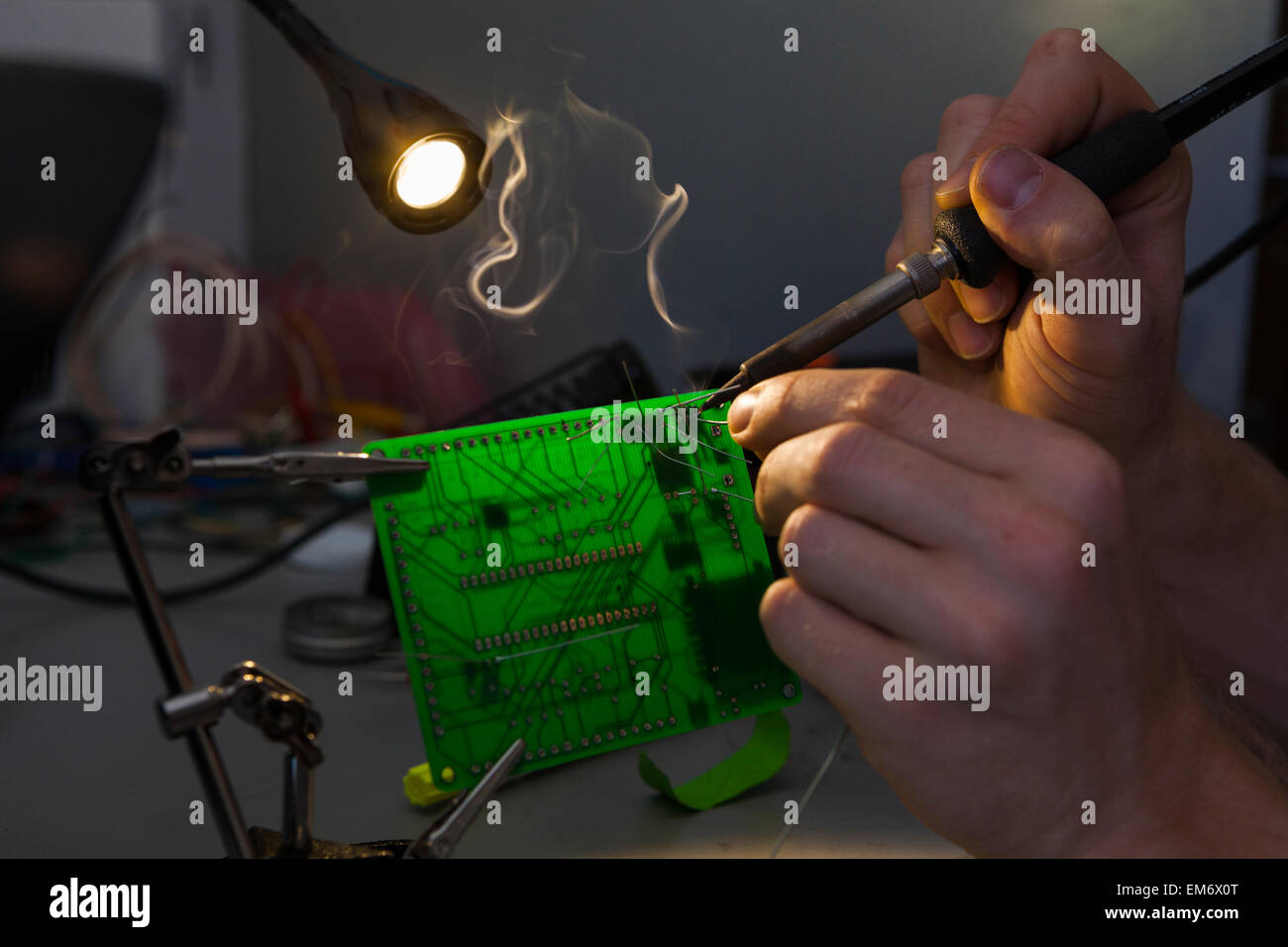 A man solders a circuit board for field instruments at a research ...
