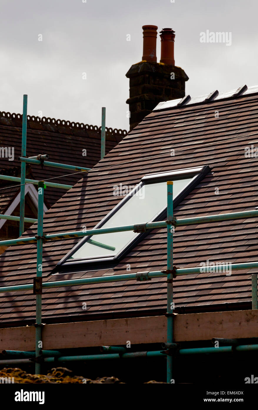 Scaffolding poles next to roof on a building site with new roof tiles ...