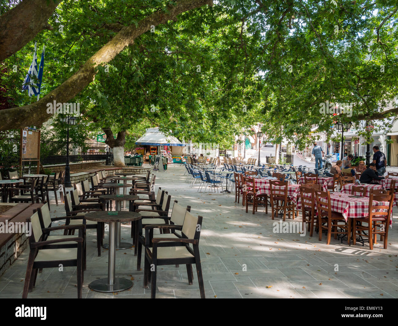 Restaurant tables under a tree shade in Karya main square Stock Photo ...