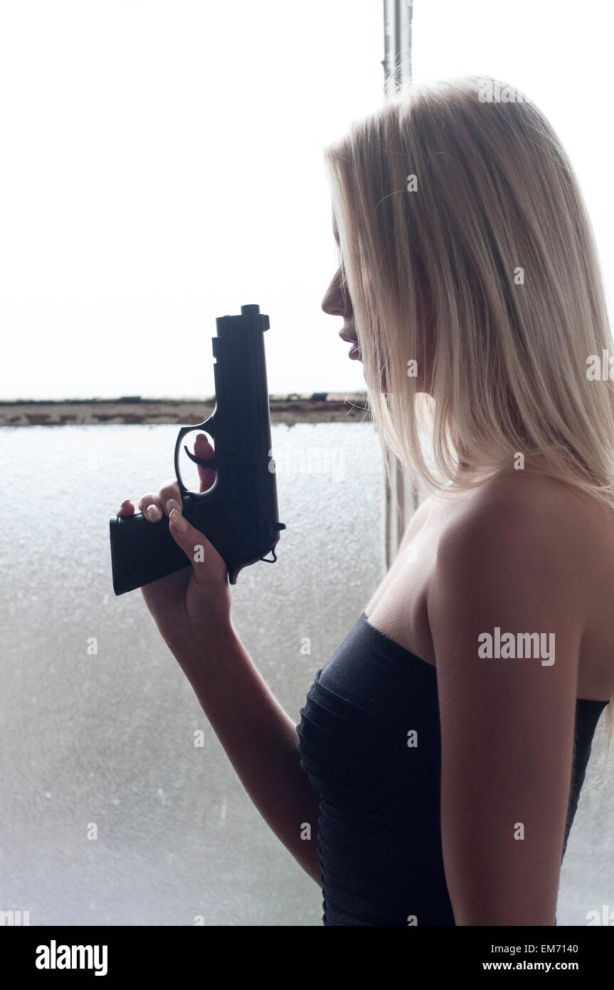 Beautiful blond holding gun hi-res stock photography and images - Alamy