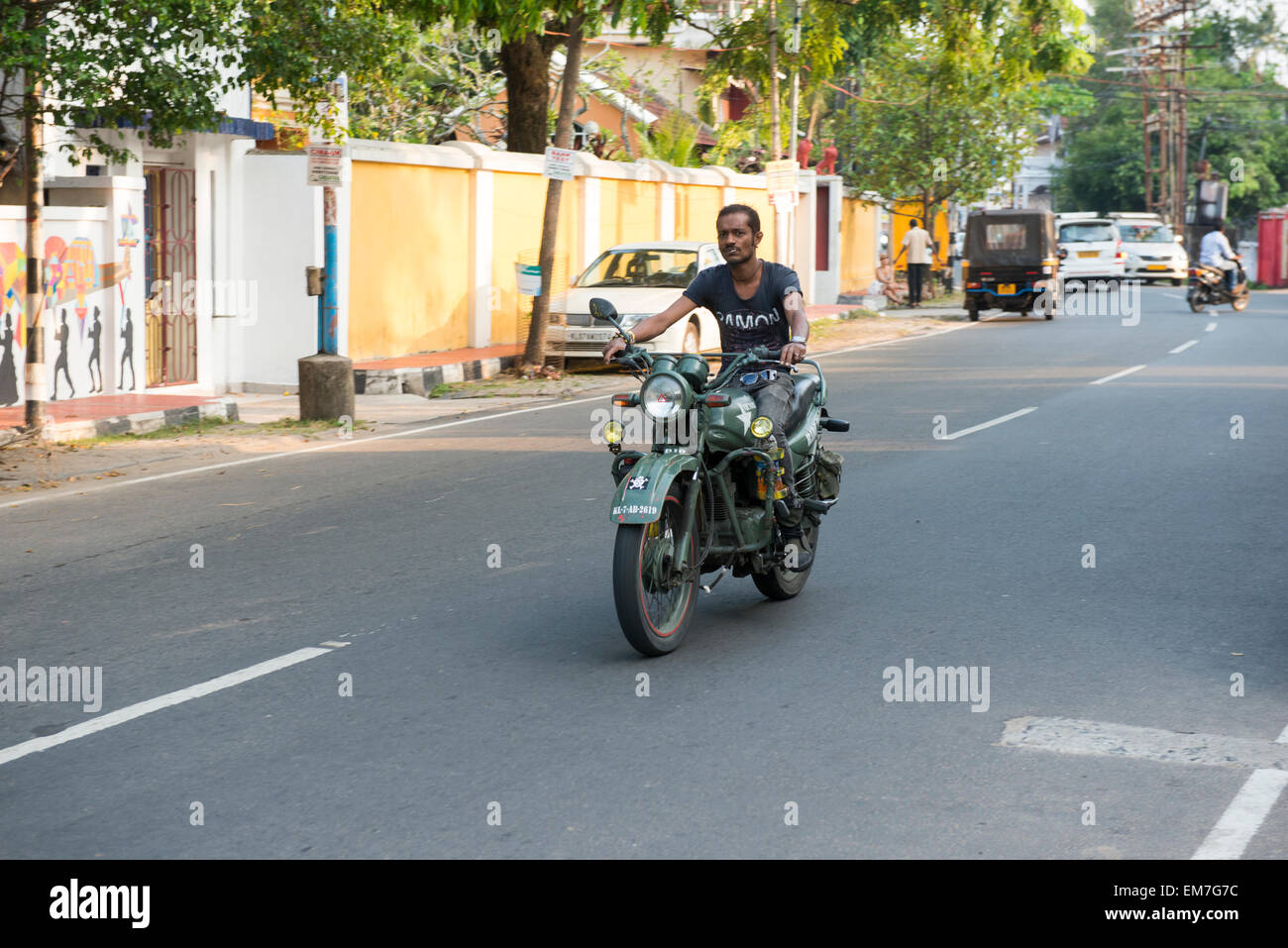 An Indian man riding his motorcycle through Fort Kochi, Kerala India ...