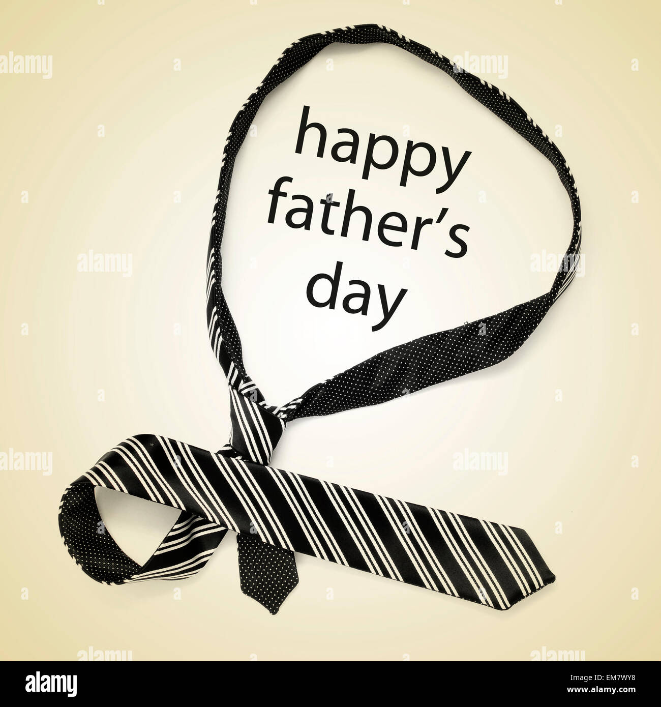 a necktie and the sentence happy fathers day on a beige background ...