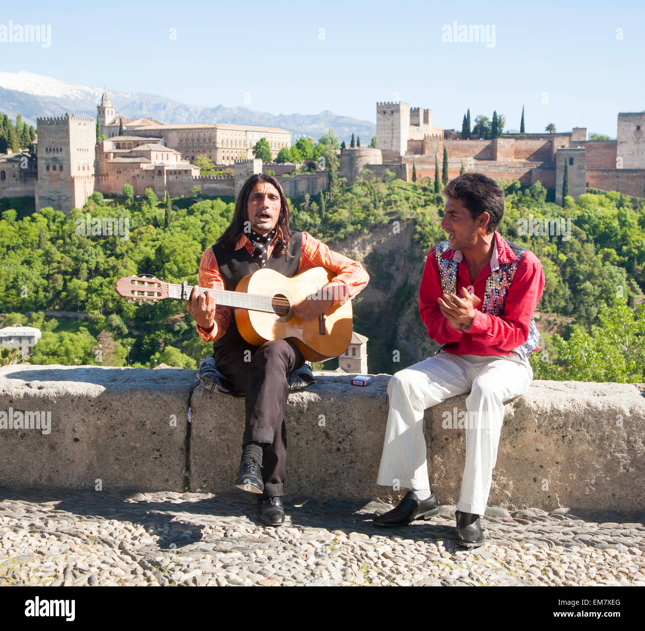 Flamenco musicians play with a backdrop of the Alhambra and snow topped ...