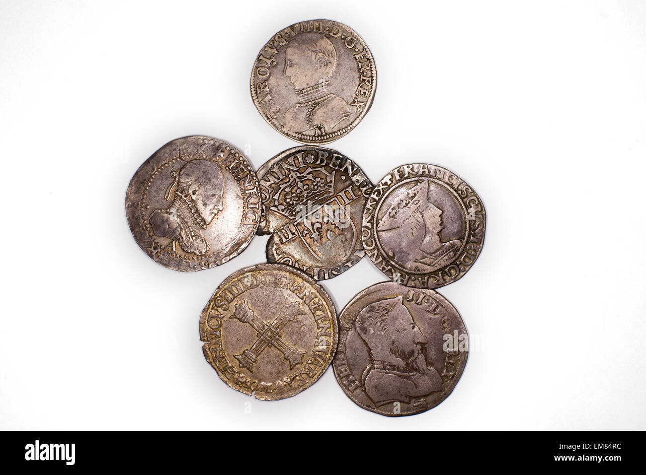 A lot of old silver coins with portraits of kings on a white background ...