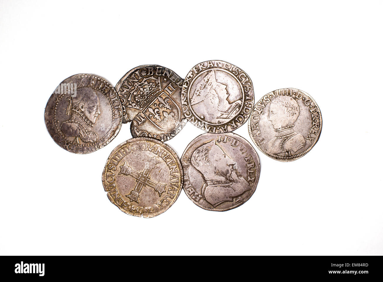 A lot of old silver coins with portraits of kings on a white background ...
