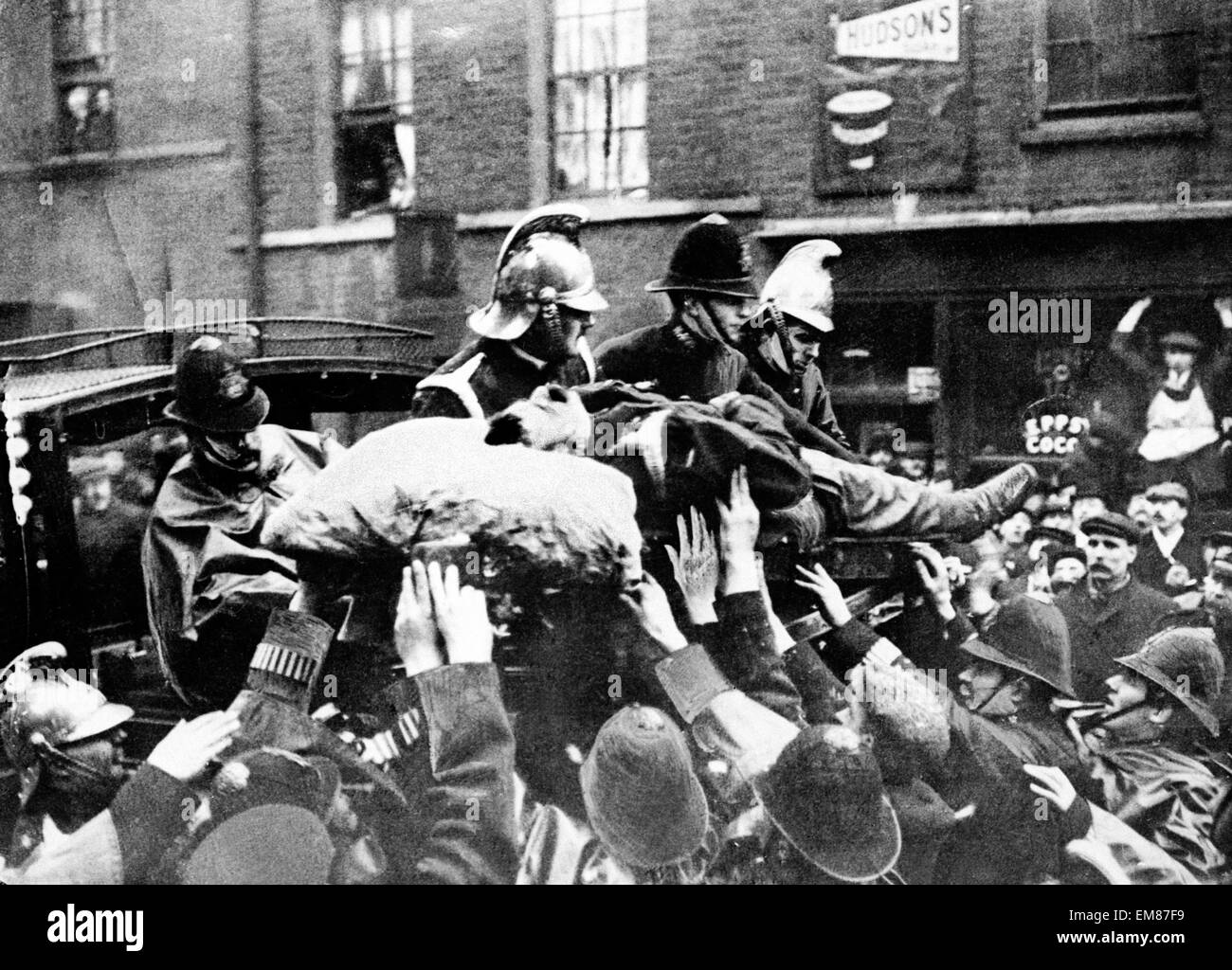 Sidney Street Seige. An injured fireman is carried away from the scene ...