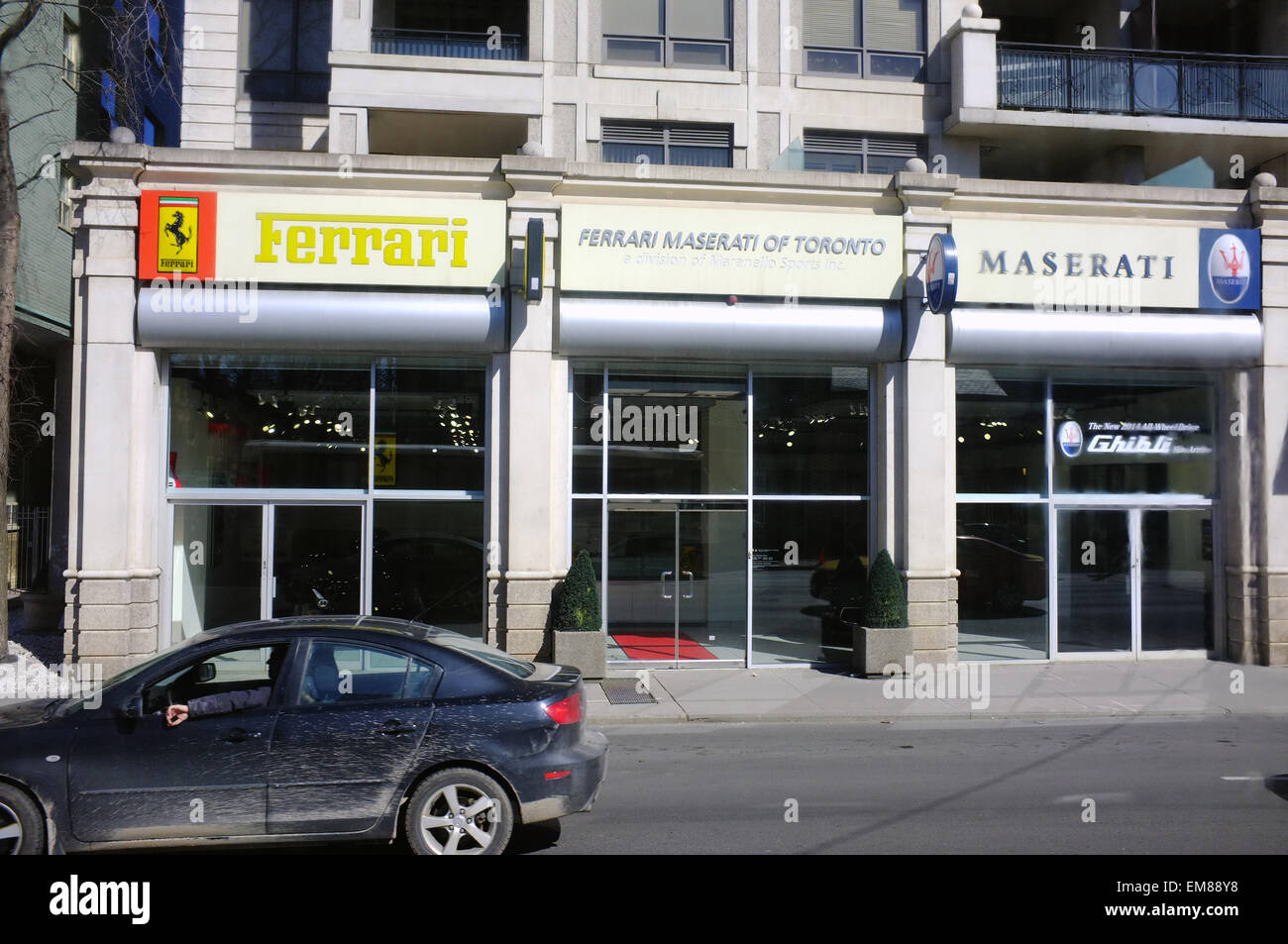 A car passes the Ferrari and Maserati car showrooms in Toronto Stock ...