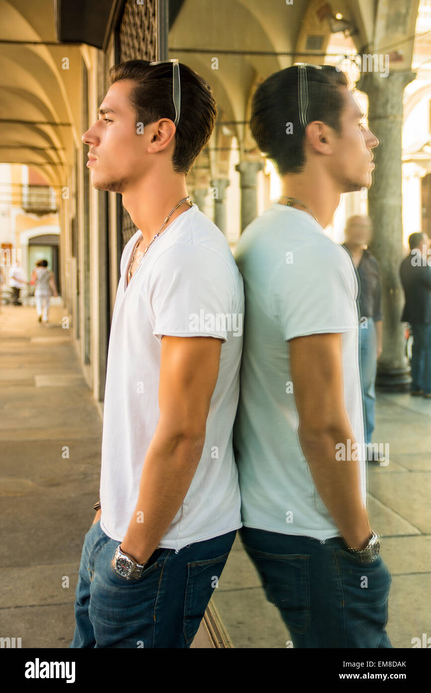 Handsome young man and his reflection in shop window outdoor Stock ...