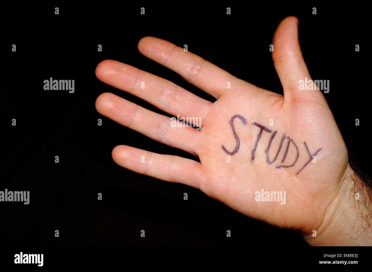 Study written on the palm of a hand photographed against a black ...