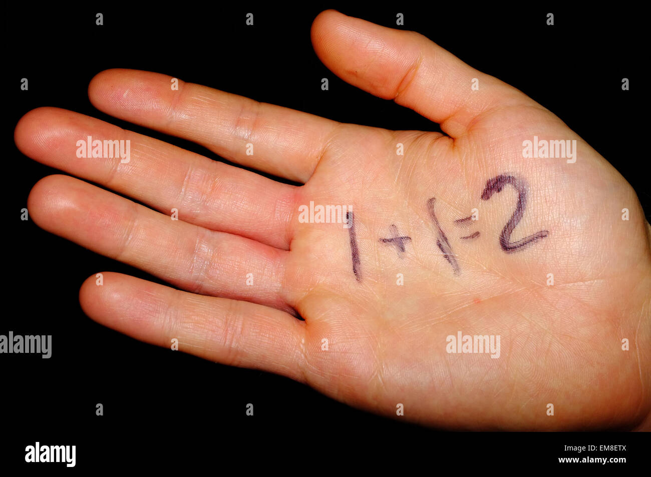 A simple maths sum written on the palm of a hand photographed against a ...