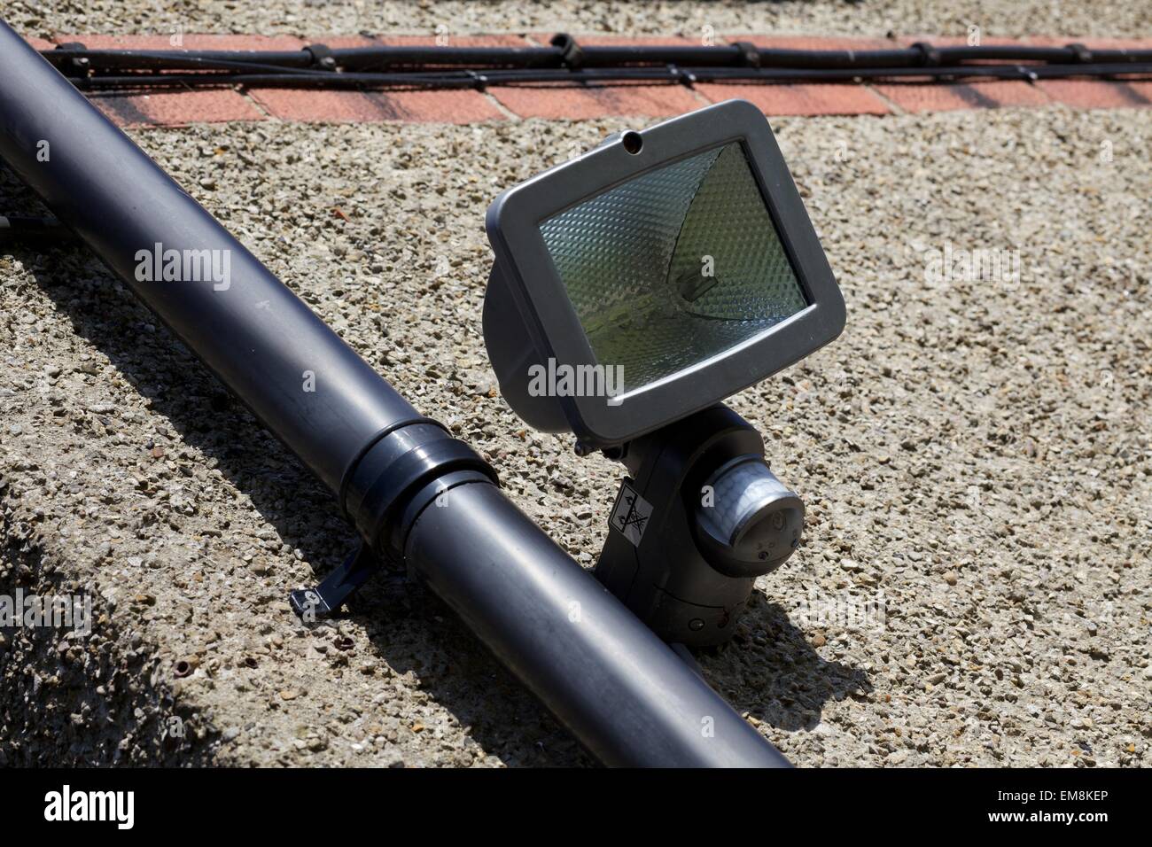 Security light and drain detail on a pebble dash building Stock Photo ...