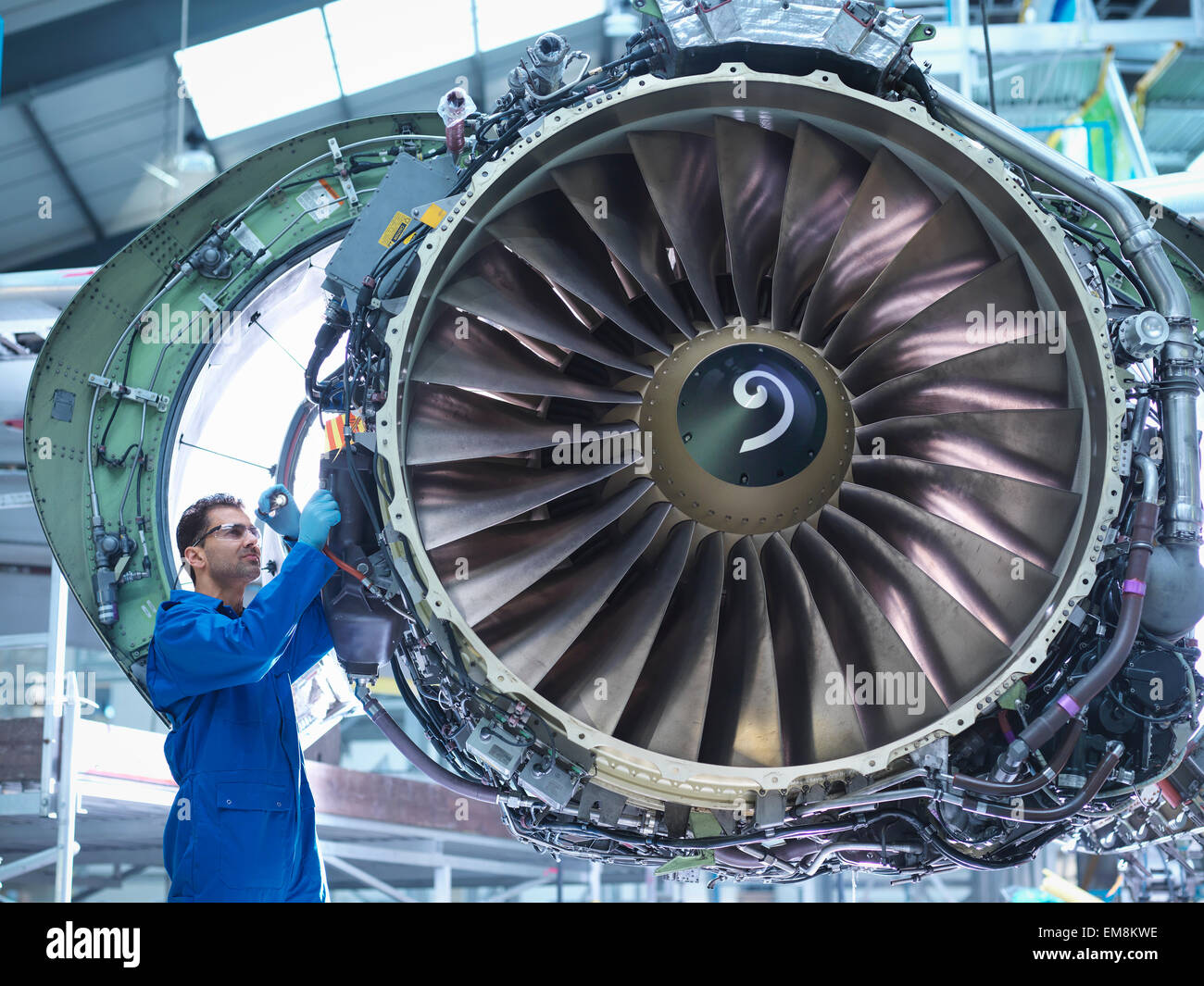 Engineers working on aircraft engine in aircraft maintenance factory ...