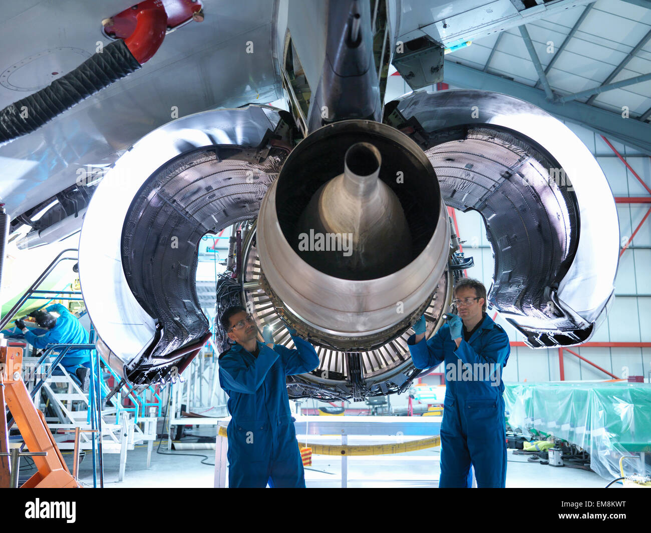 Engineers working on jet engine in aircraft maintenance factory Stock ...