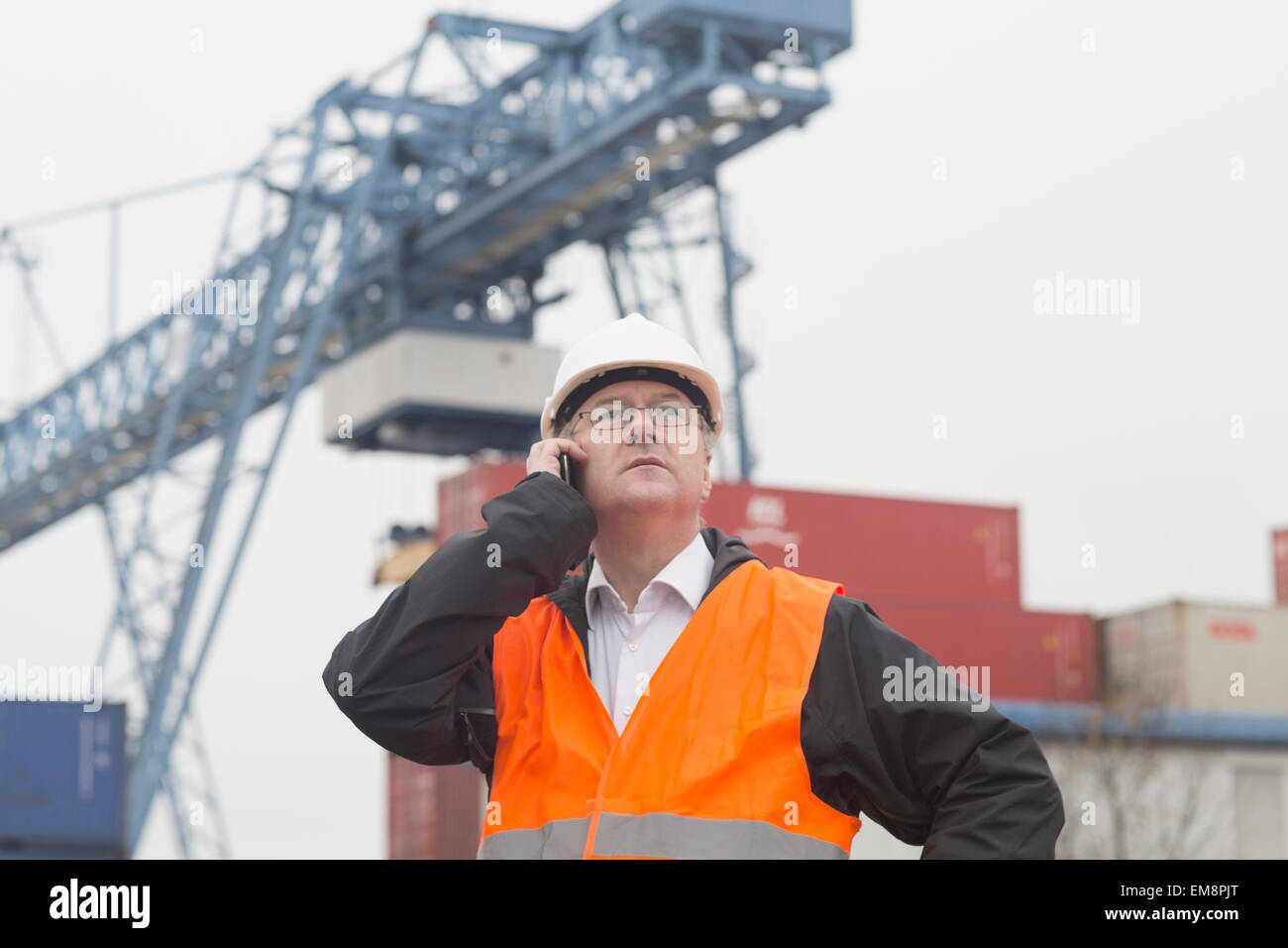 Dock worker using smartphone at port Stock Photo - Alamy