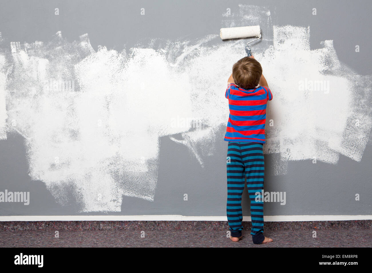 Rear view of boy painting wall Stock Photo - Alamy