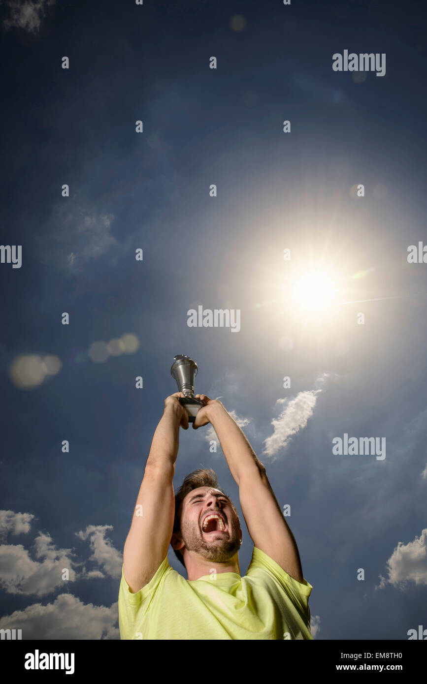 Young male sportsman celebrating holding up winners trophy Stock Photo ...