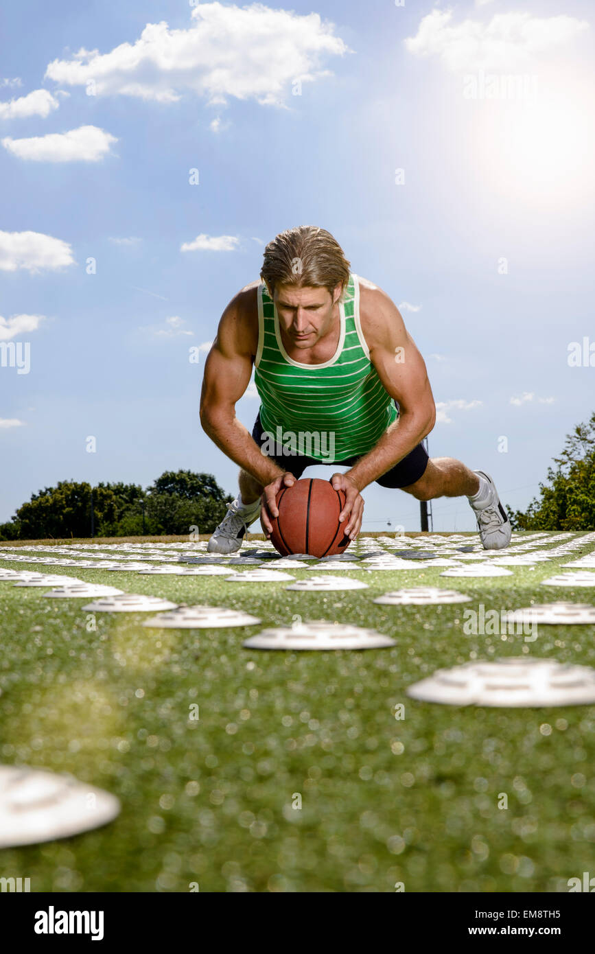 Mid adult male basketball player doing push ups on ball Stock Photo - Alamy