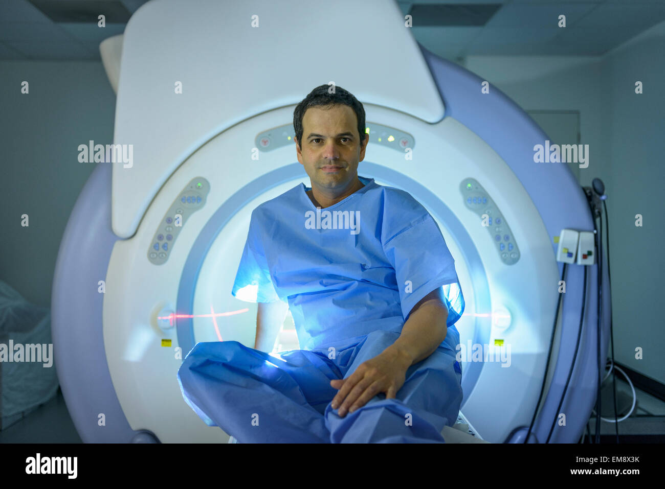 Patient sitting on Magnetic Resonance Imaging (MRI) scanner, portrait ...