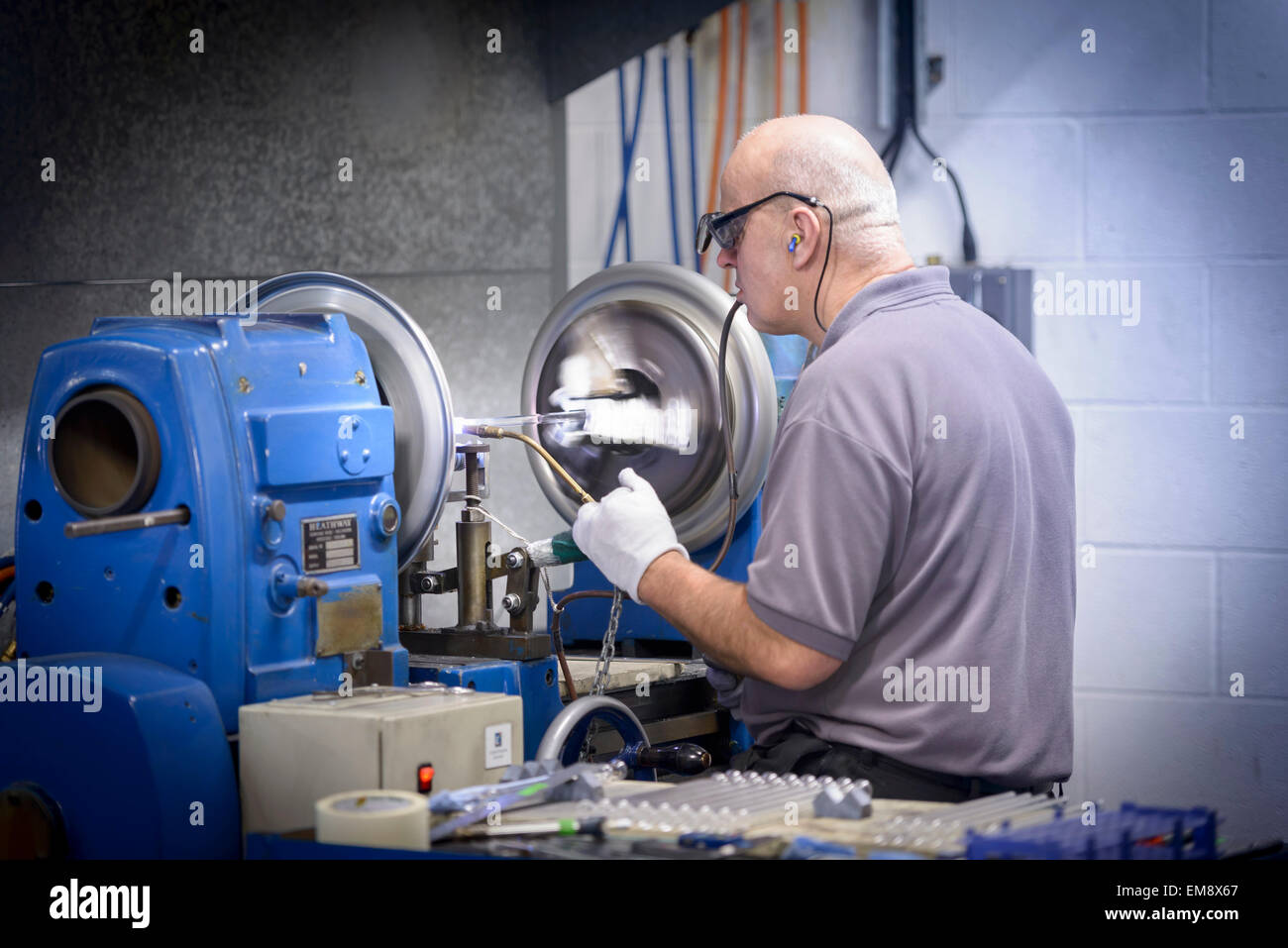 Industrial glass blower forming glass tube on lathe Stock Photo - Alamy