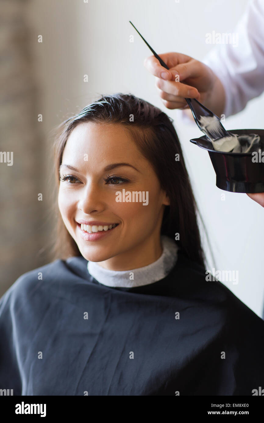 happy woman with stylist coloring hair at salon Stock Photo - Alamy