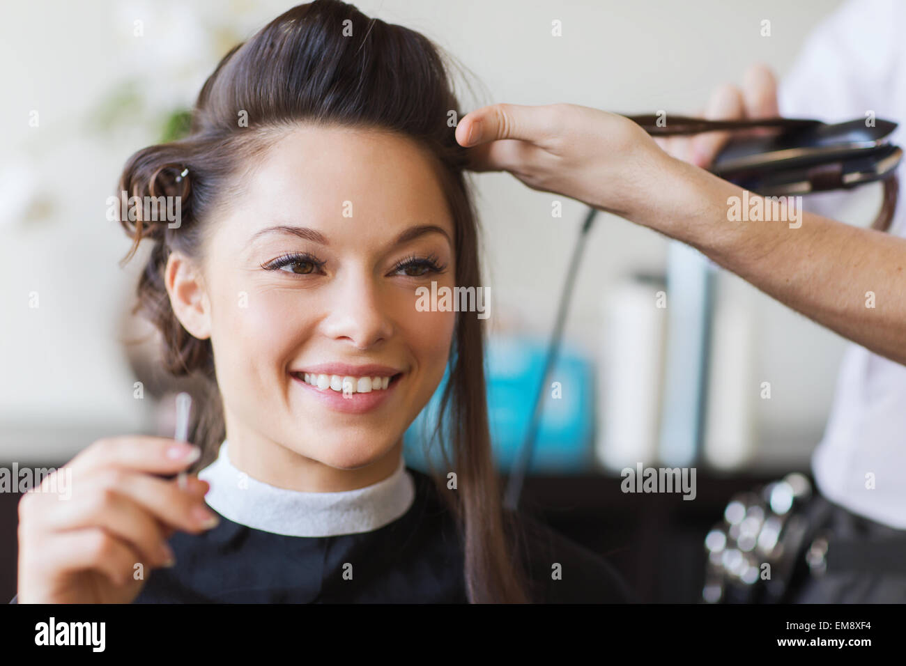 happy woman with stylist making hairdo at salon Stock Photo - Alamy