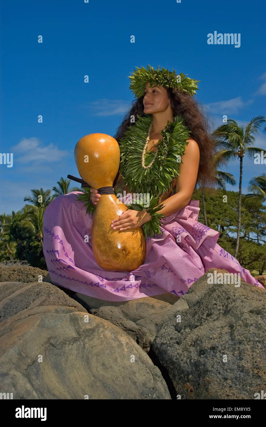 Hula Dancer With Haku Lei In Traditional Outfit On Rocky Shore Holding ...