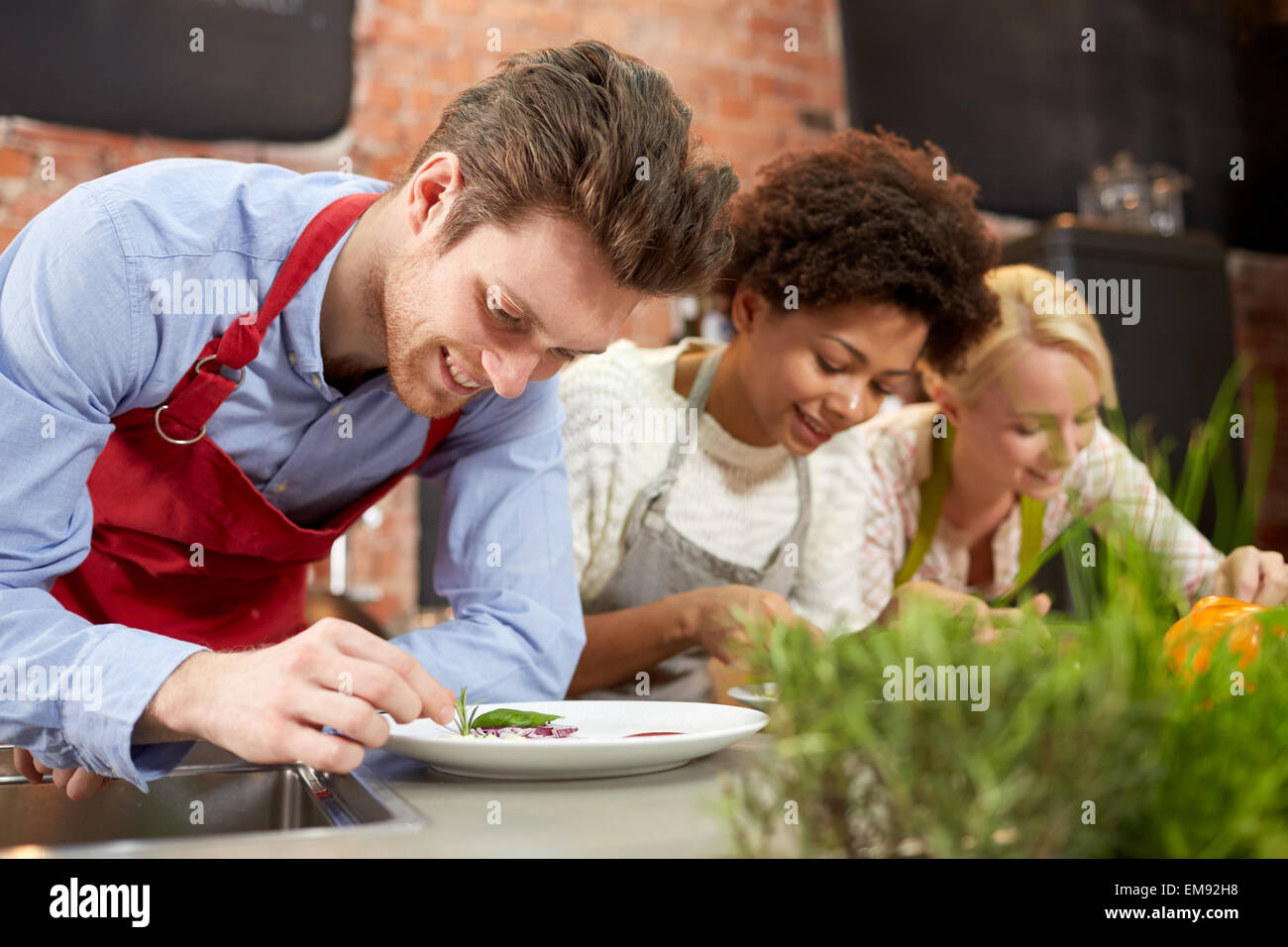 happy friends cooking and decorating dishes Stock Photo - Alamy