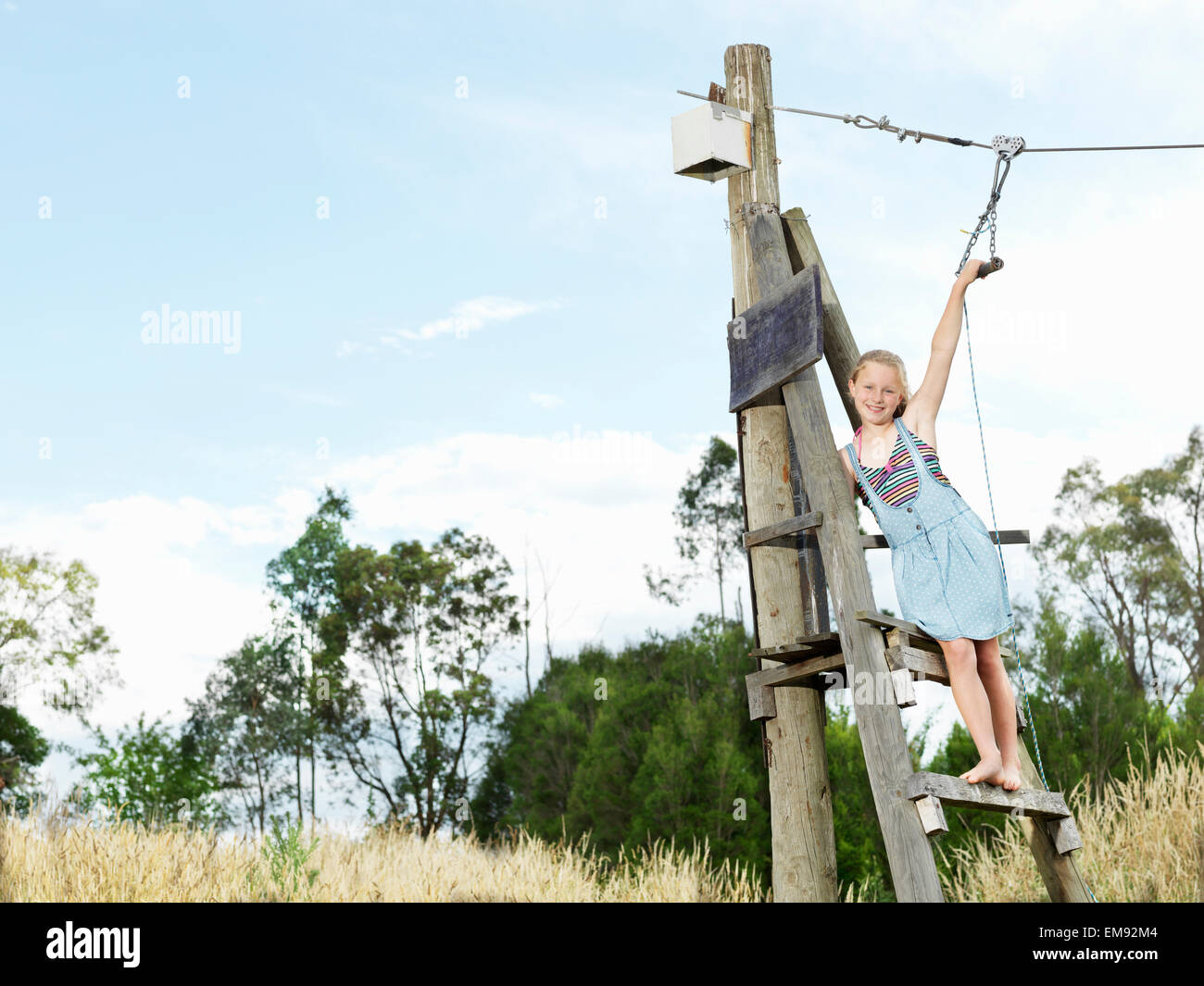 Girl ready to swing on rope slide Stock Photo - Alamy