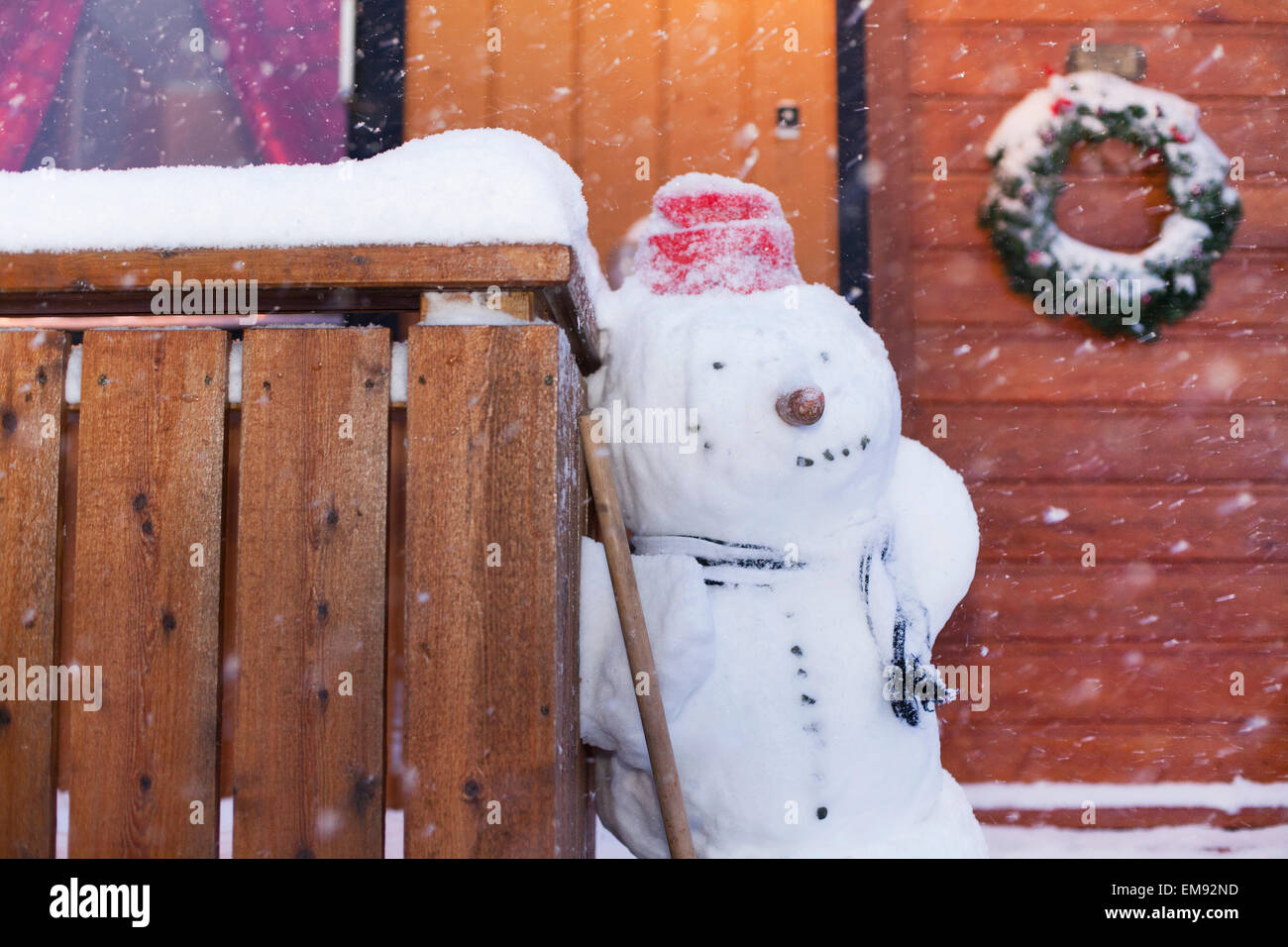 Snowman standing against wooden fence Stock Photo - Alamy