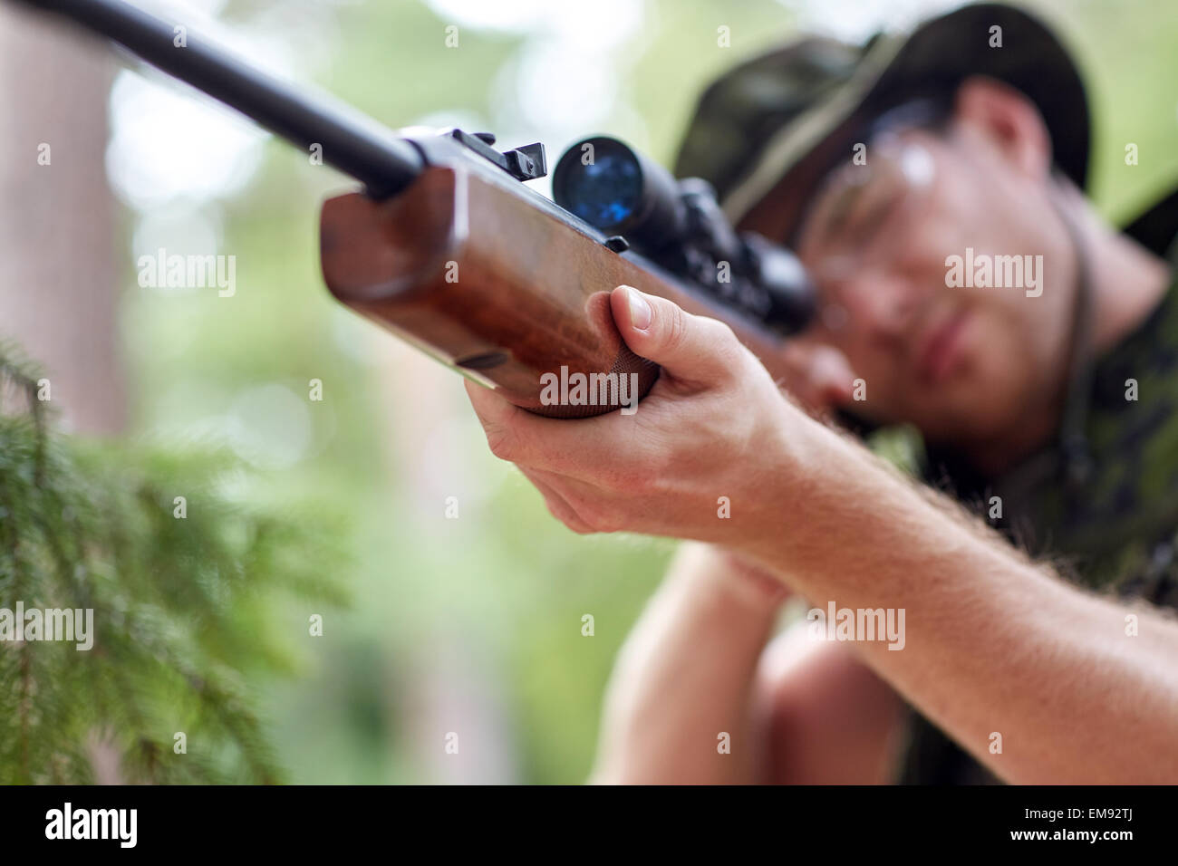 soldier or hunter shooting with gun in forest Stock Photo - Alamy