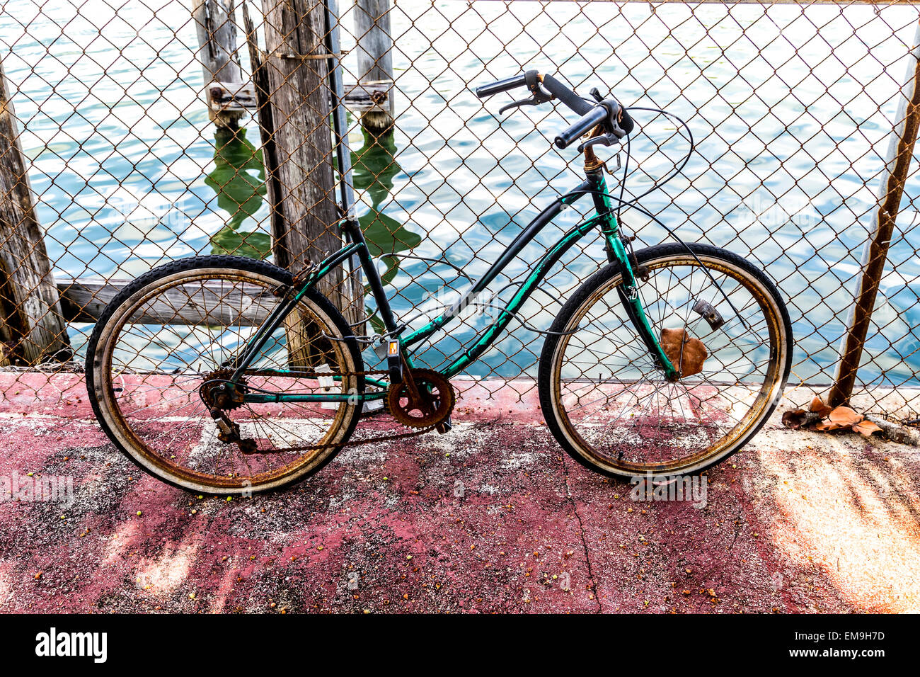 old rotten bike at a rusty fence at the canal in Miami Stock Photo - Alamy