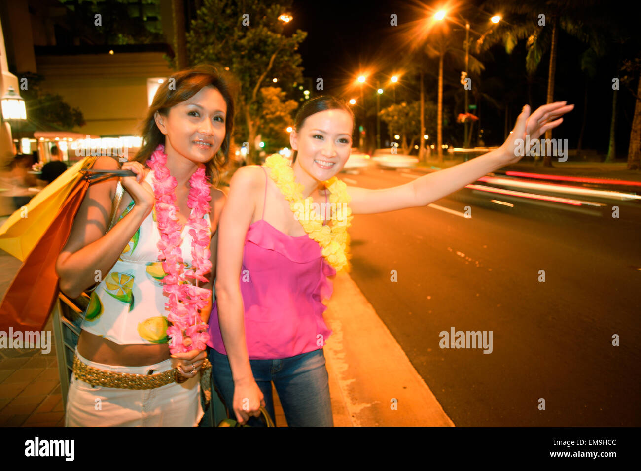 Hawaii, Oahu, Honolulu, Two Female Japanese Tourists Hail A Taxi In ...