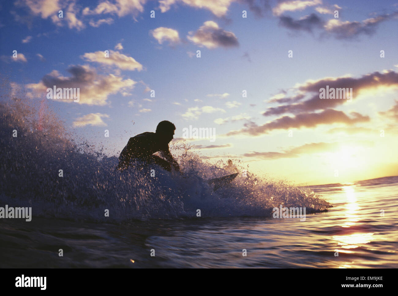 Surfer Riding Small Whitewater Wave At Sunset Stock Photo - Alamy