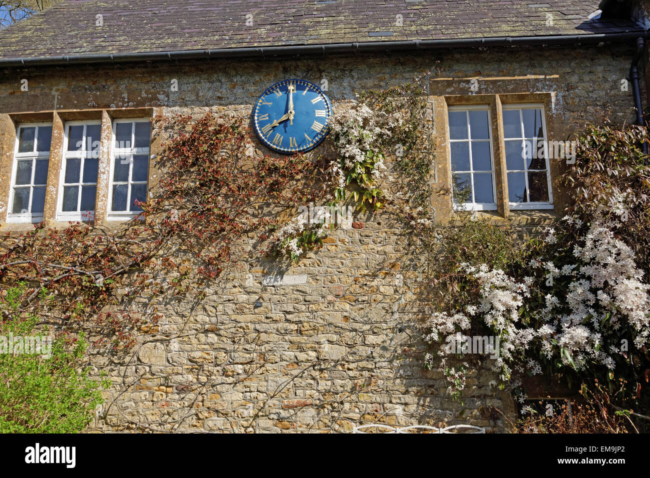 Blue clock on side of house in Dorset Stock Photo - Alamy