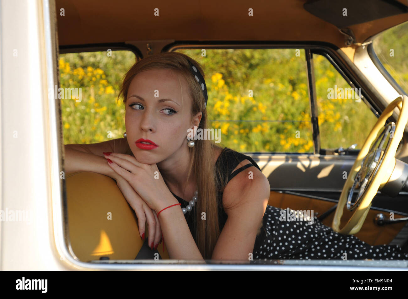 Closeup portrait of young woman inside old-fashioned car sitting on ...