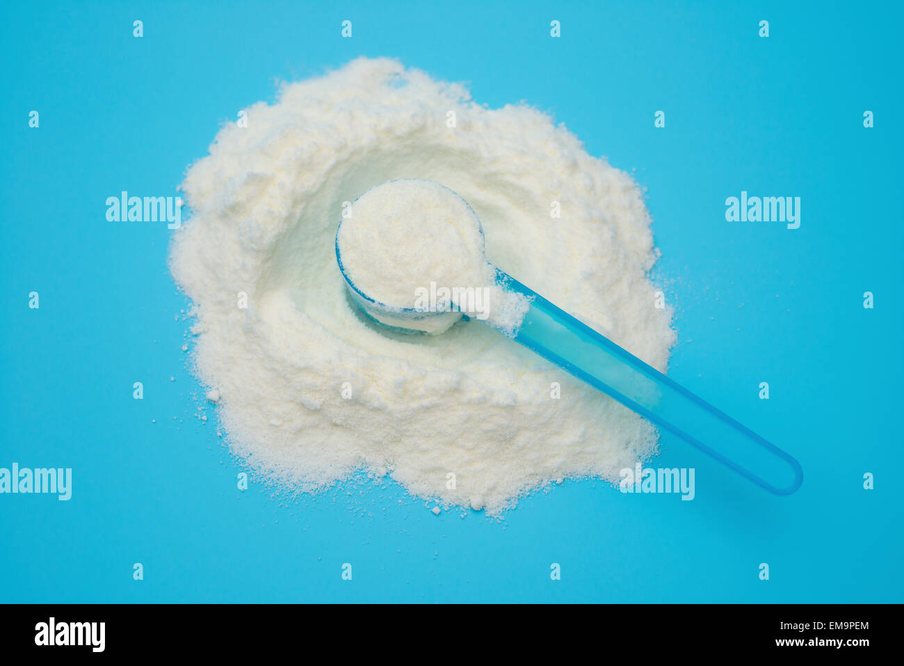 powdered milk in a blue spoon on blue background, closeup Stock Photo ...