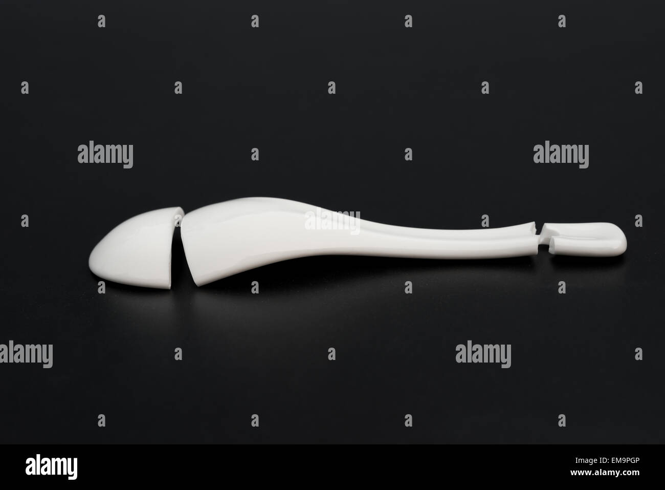broken porcelain spoon on a black background Stock Photo - Alamy
