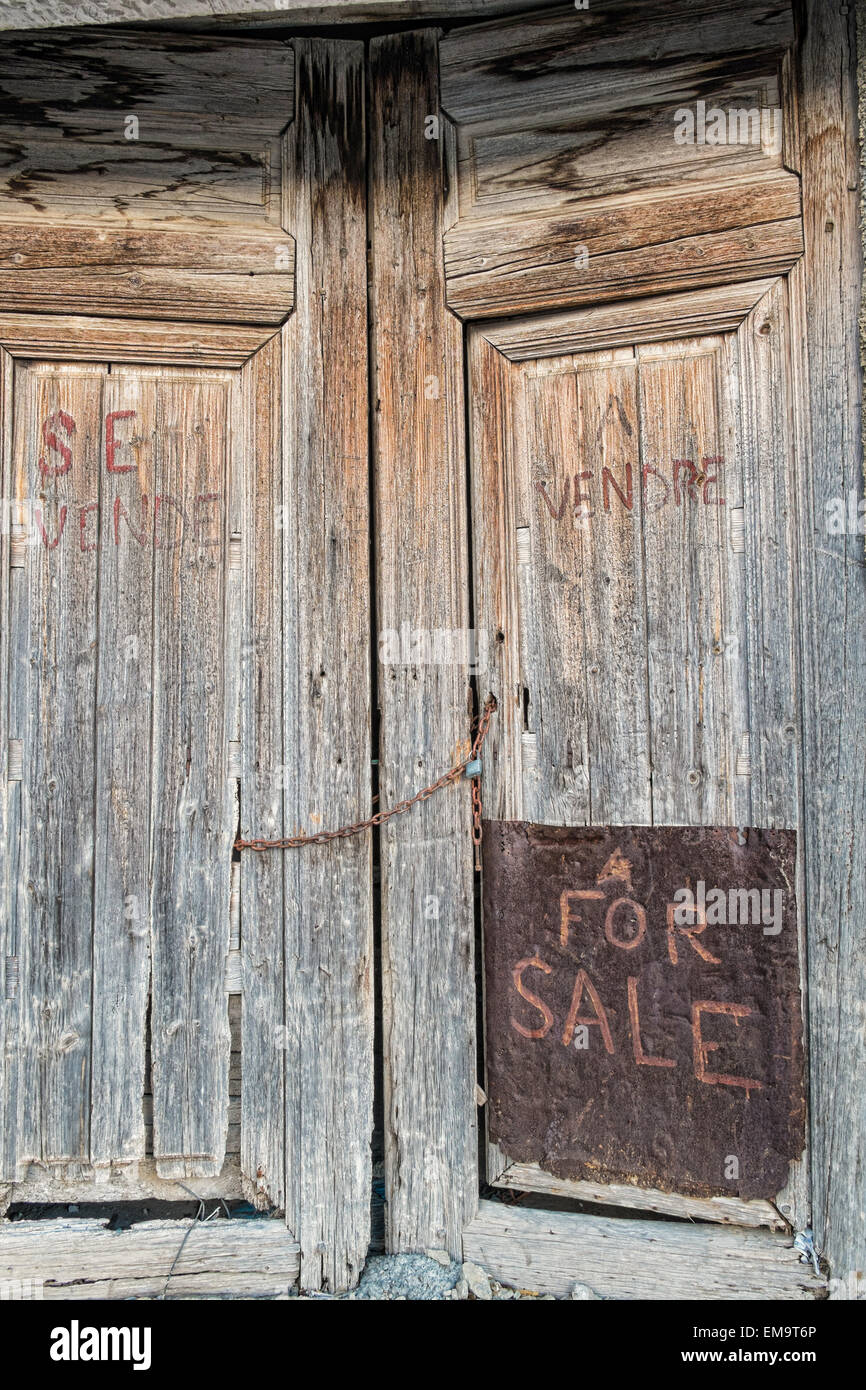 "For sale" handwritten on a derelict door, a real estate crunch concept ...