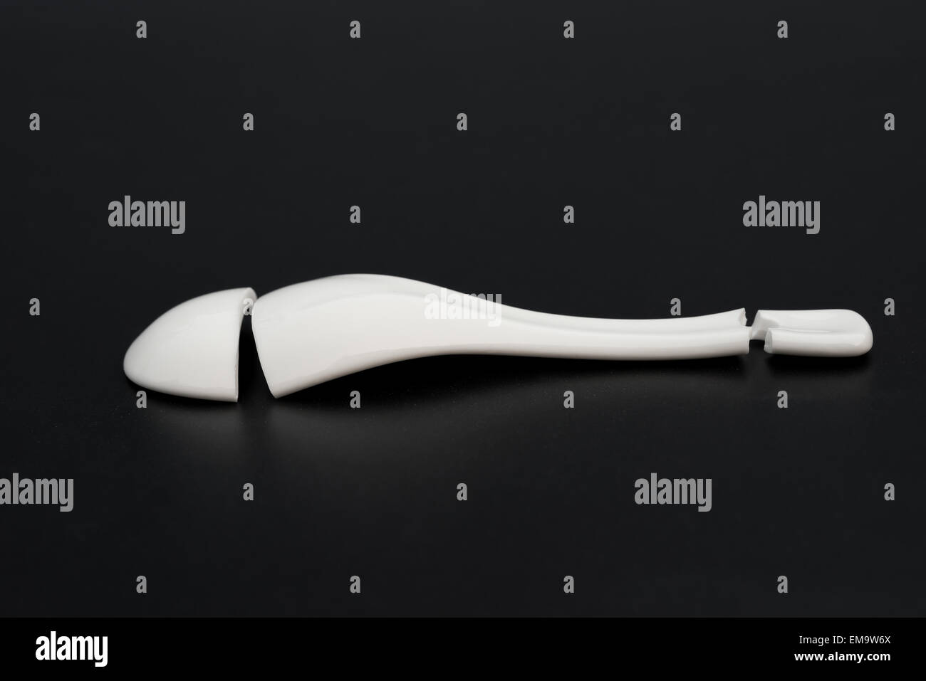 broken porcelain spoon on a black background Stock Photo - Alamy