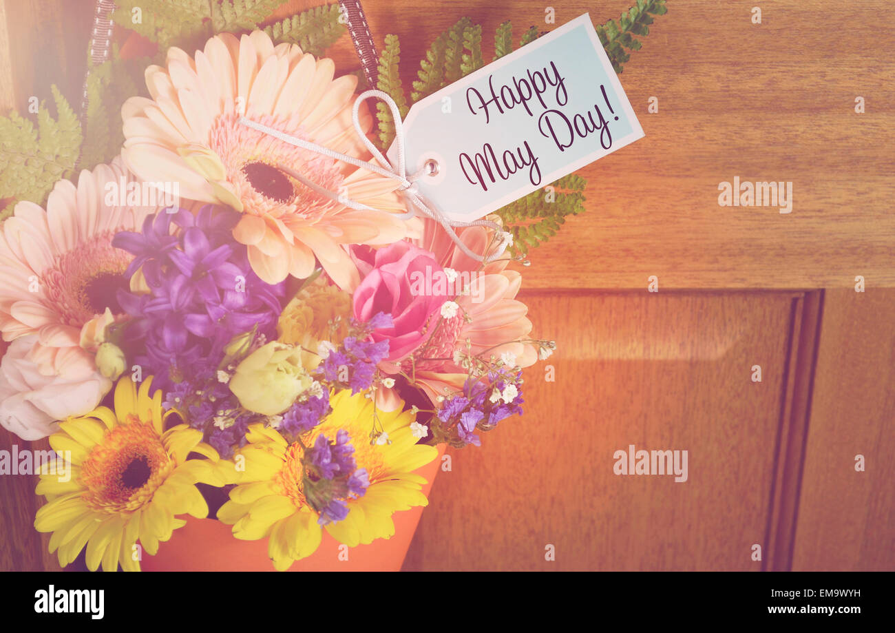 Happy May Day traditional gift of Spring flowers in orange cone hanging ...