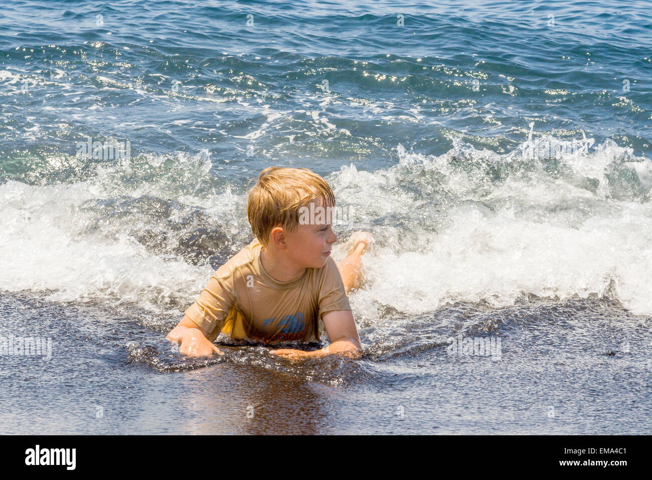 cute boy has fun playing in the waves Stock Photo - Alamy