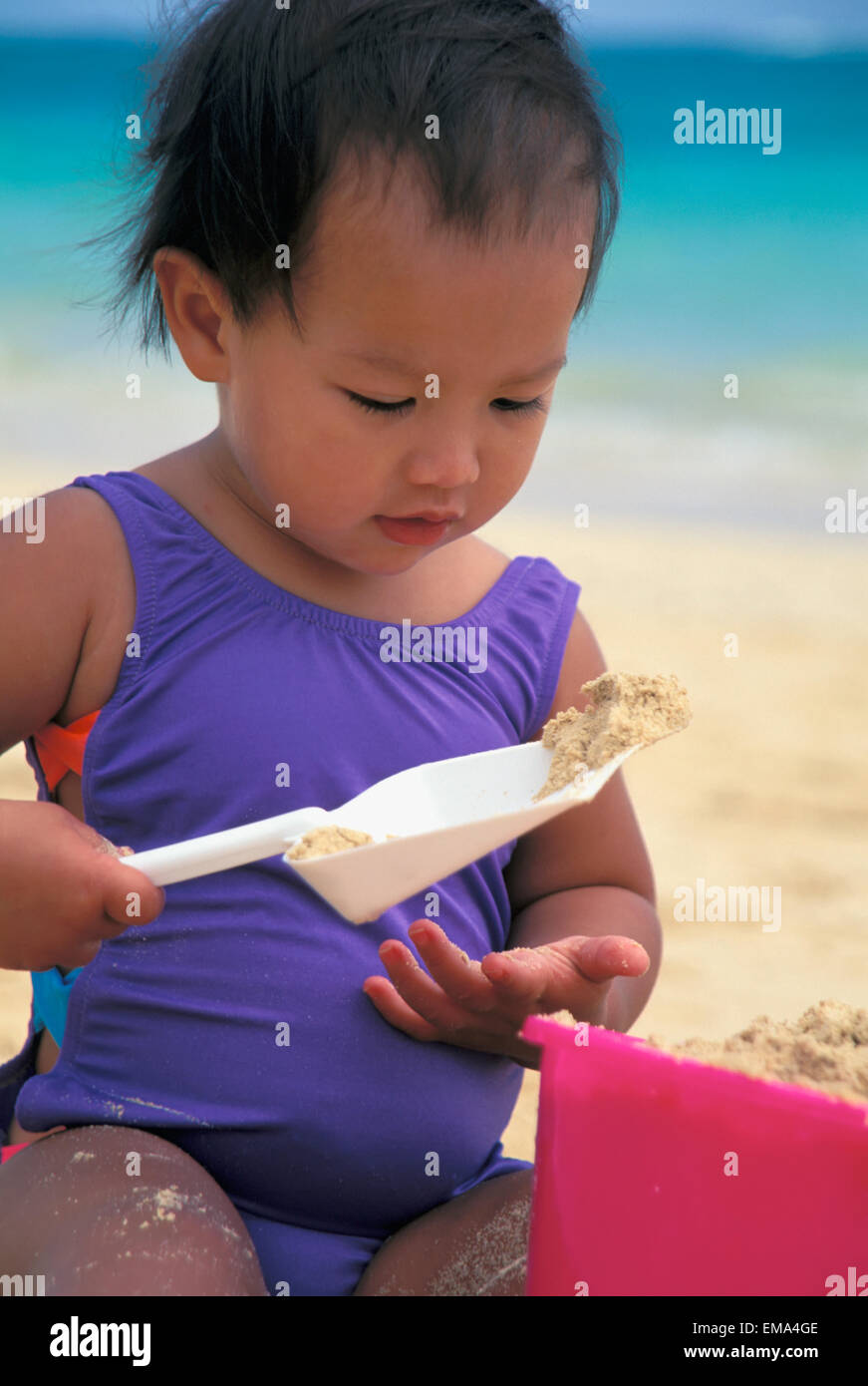 Close-Up Of Little Girl In Purple Bathing Suit Playing In Sand, Bucket ...