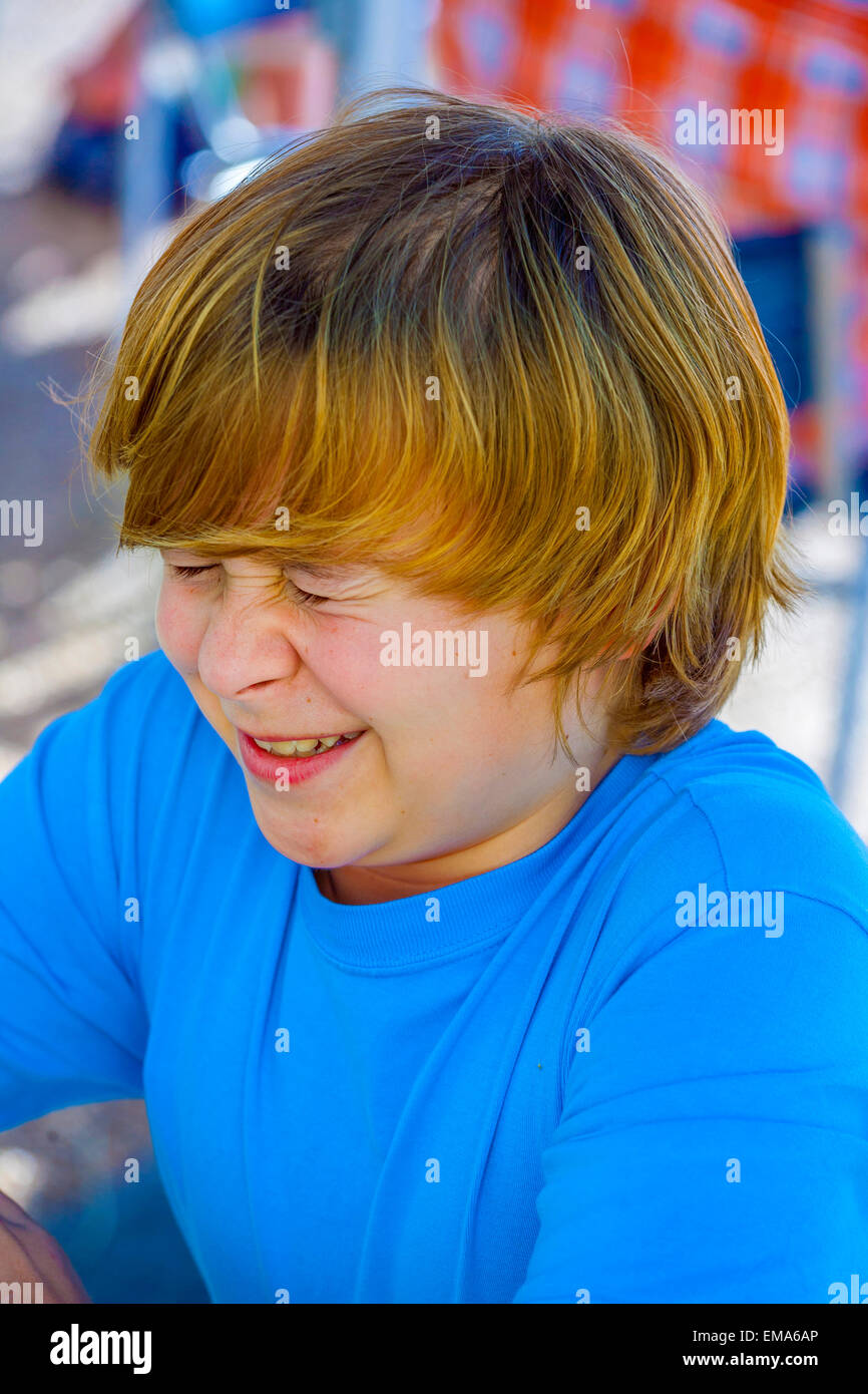 outdoor portrait of relaxed cute young boy looking positive and ...