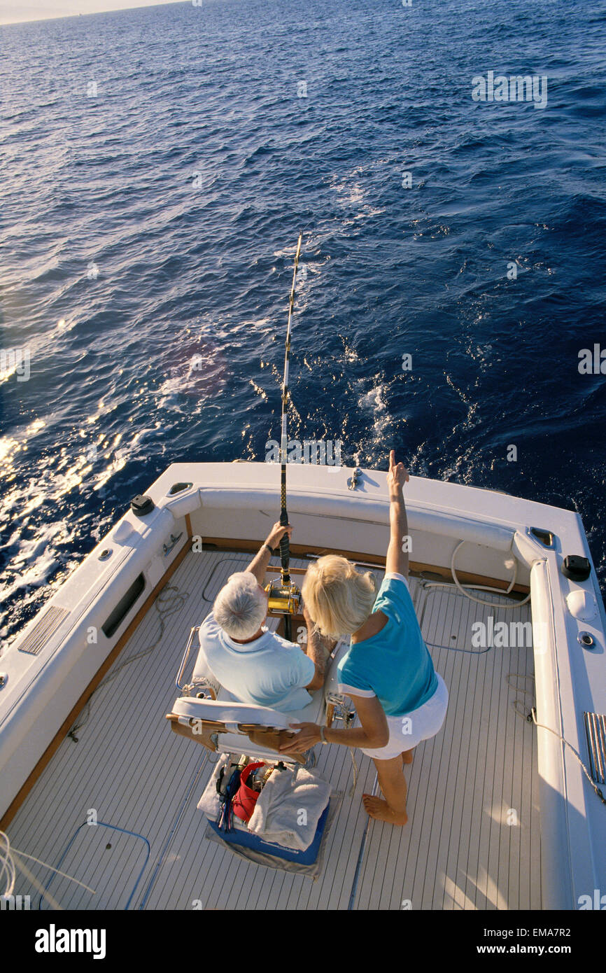 View From Behind Senior Couple In Back Of Boat, Man In Chair Woman ...