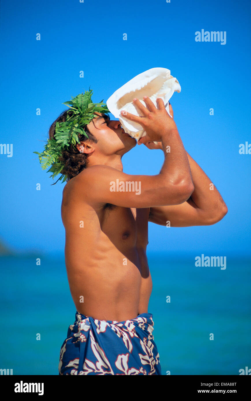 Polynesian Male With Fern Haku Blows Conch Shell, Blue Sky And Water ...