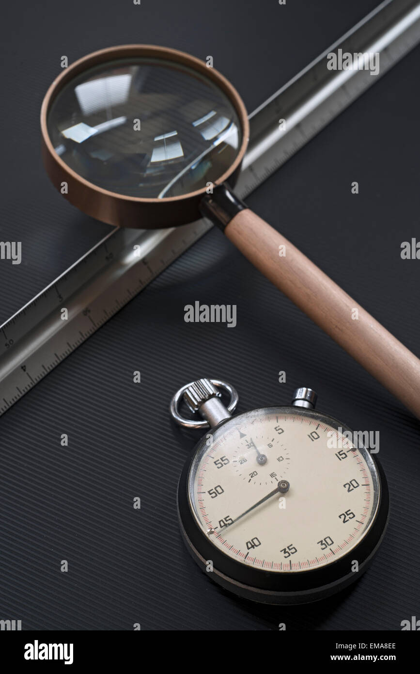 stopwatch, ruler and magnifying glass on black background Stock Photo ...